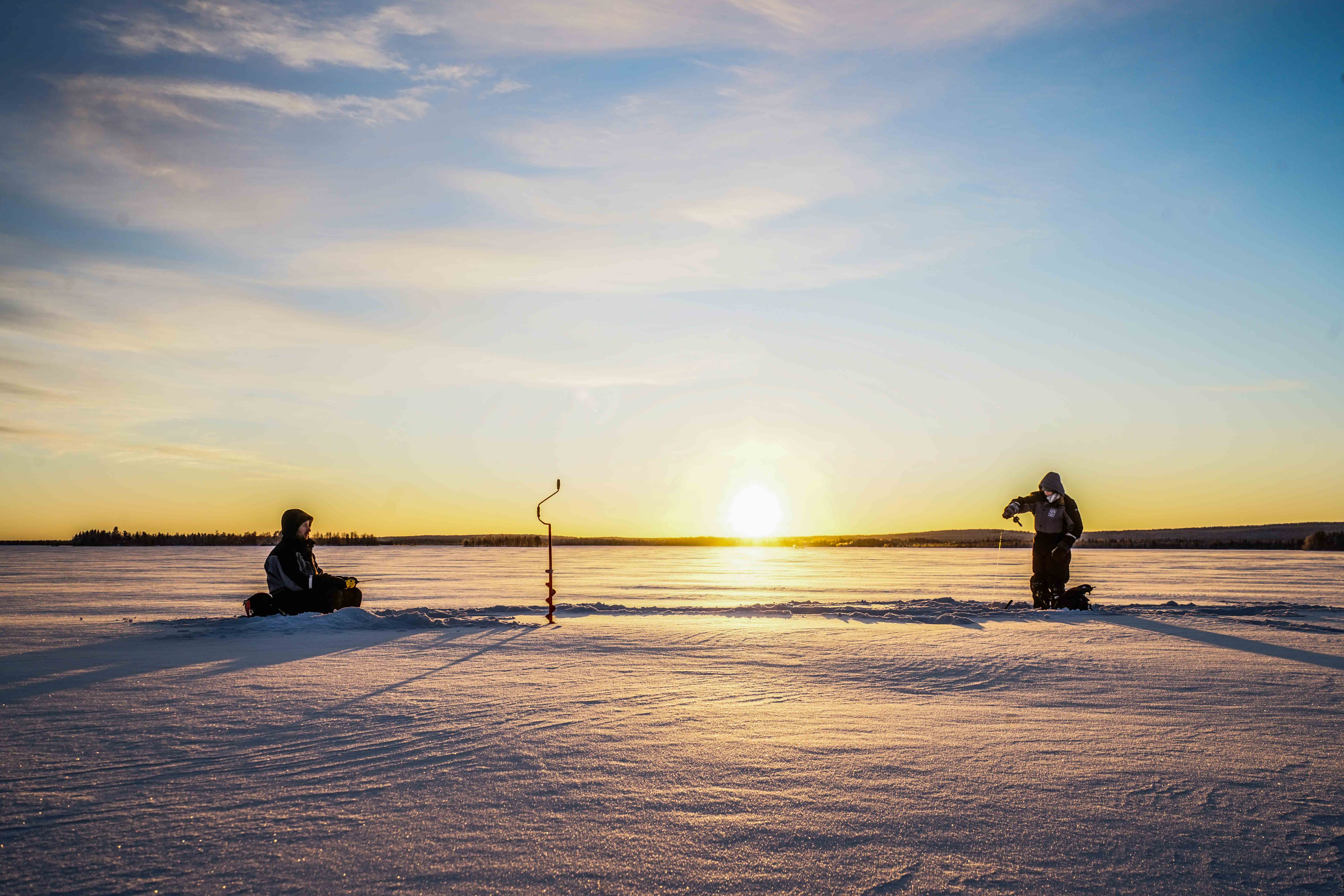 Ice fishing on a frozen lake - Beyond Arctic Rovaniemi